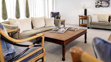 Uma sala de estar com sofá, mesa de centro e poltrona.