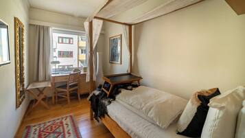 Um quarto com uma cama, uma escrivaninha e uma cadeira.