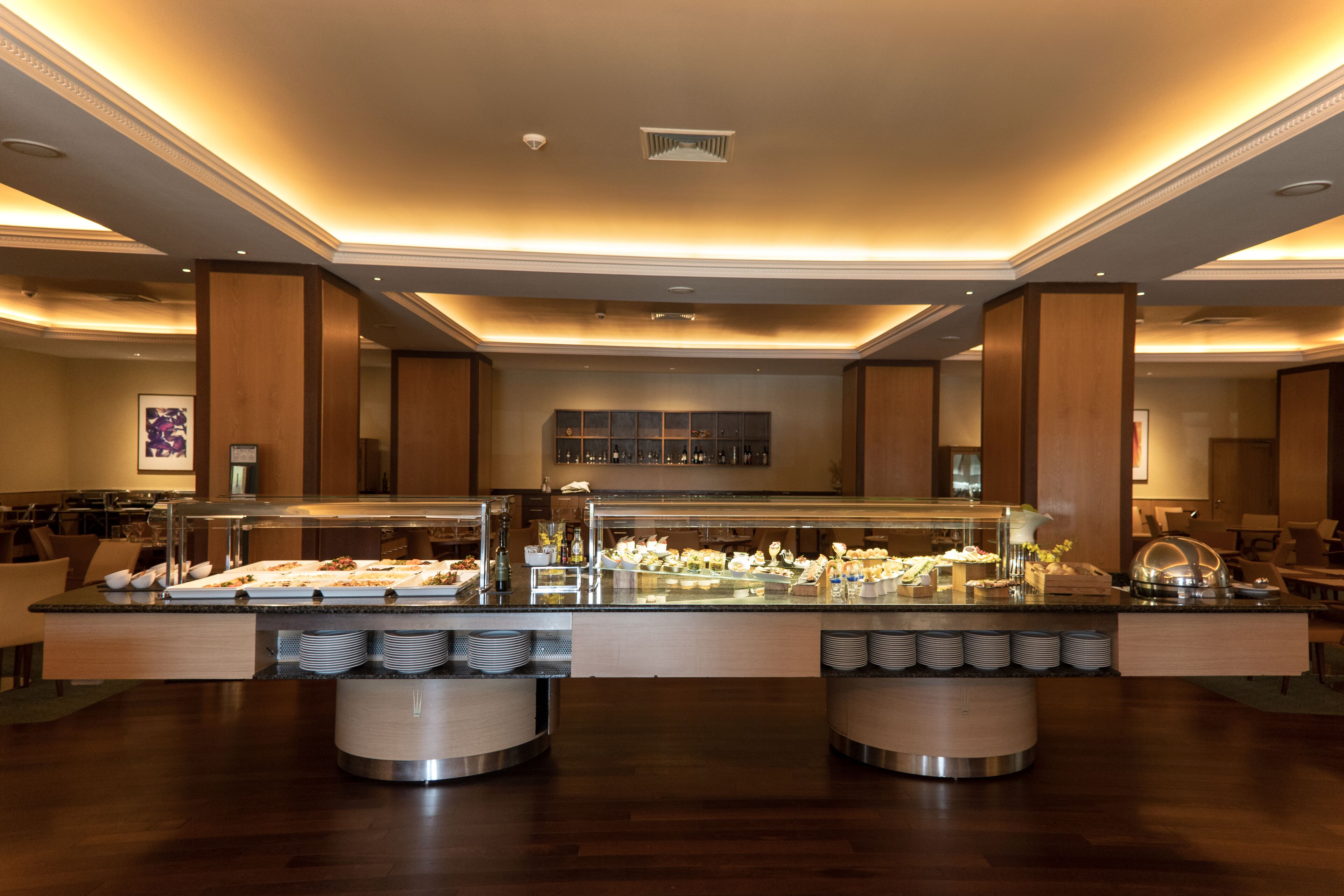 Uma mesa de buffet com diversos tipos de comida e um amplo balcão de serviço.
