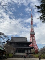 Um edifício tradicional japonês com uma grande torre vermelha ao fundo.