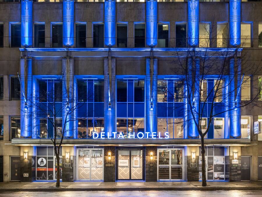 Um edifício moderno com um destaque para a placa da "Delta Hotels".