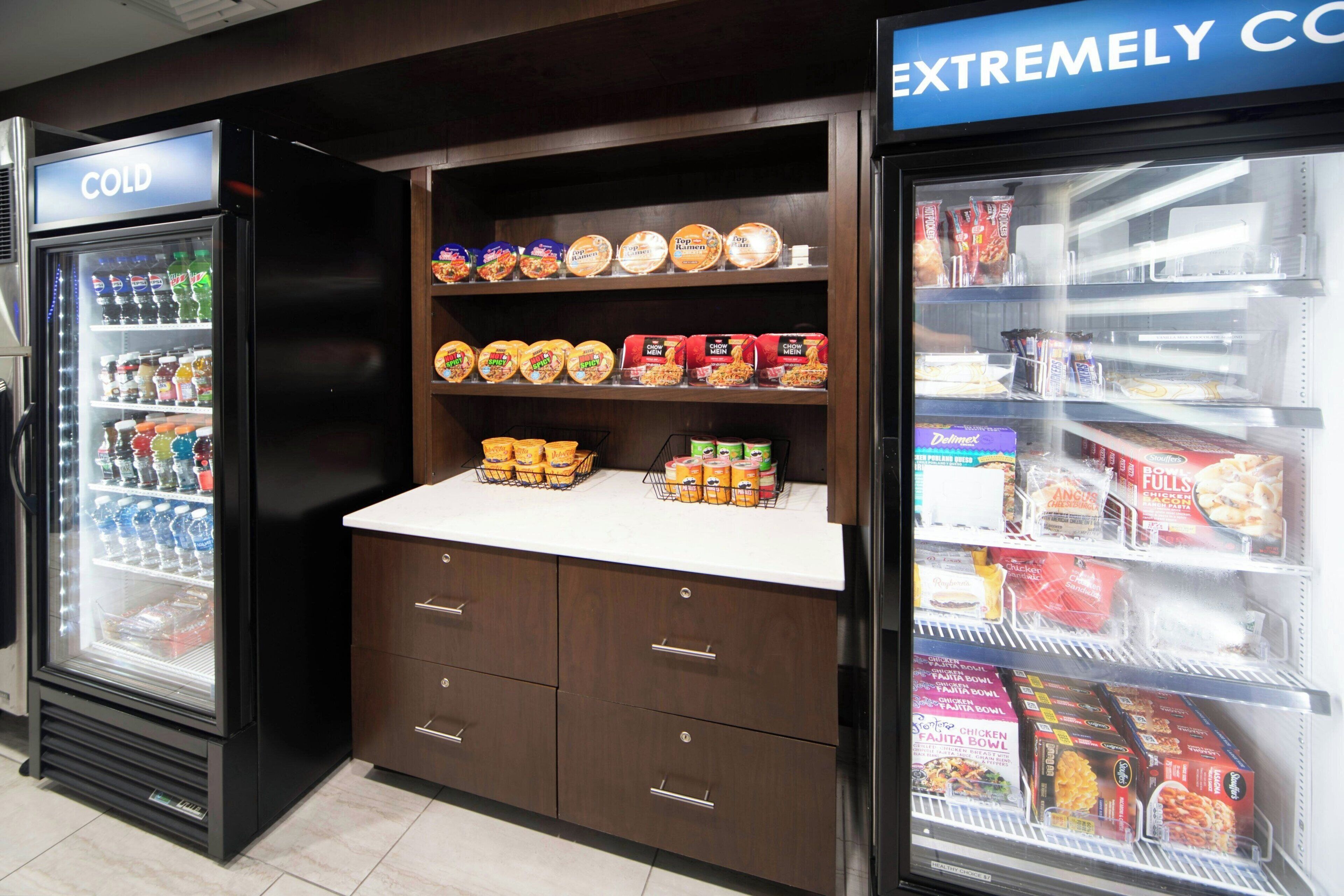 Vitrine refrigerada com diversos alimentos e bebidas.