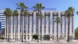 Um hotel com fachada moderna, vários andares e uma série de janelas.