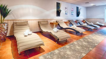 Um espaço de spa com vários espreguiçadeiras, um tapete estampado e obras de arte nas paredes.