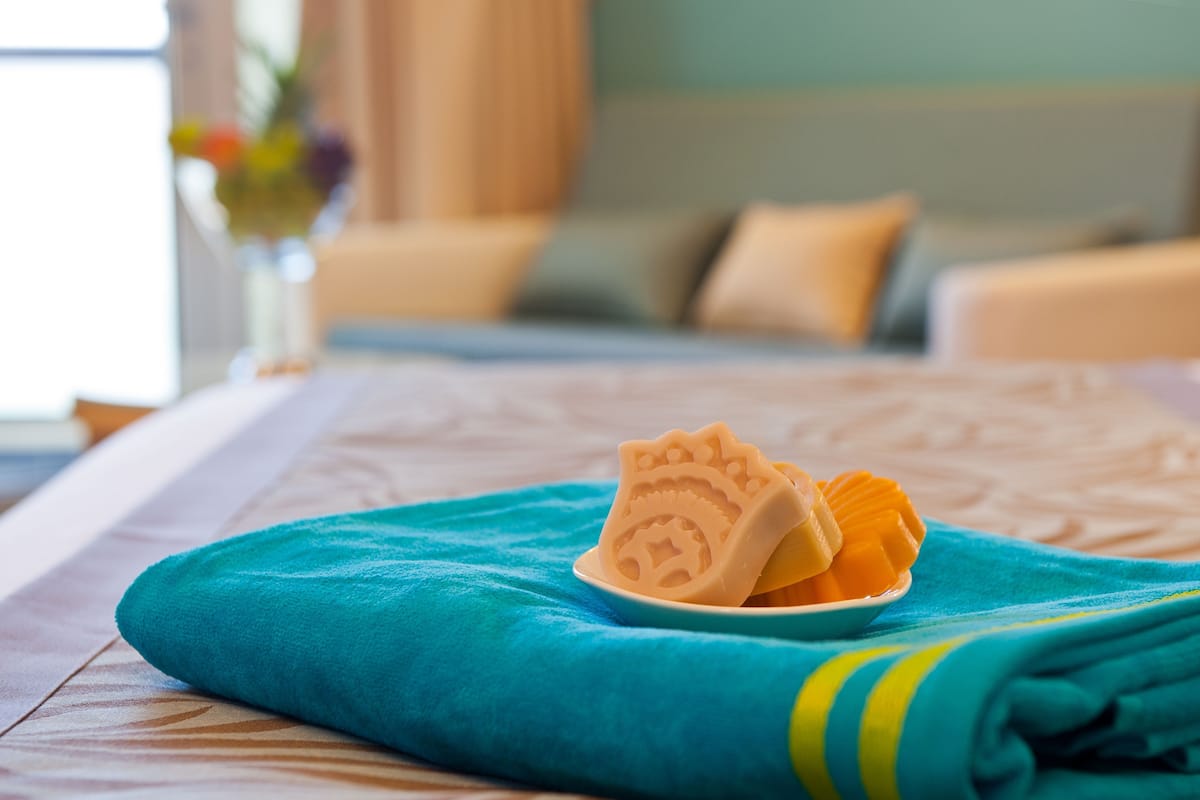 Cama com cobertor azul e um prato com sabonete e escova de dentes.