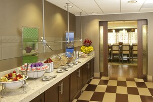 Uma área de buffet com diversos alimentos e utensílios.