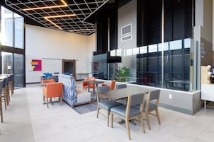 Um espaço de escritório moderno com uma grande mesa de reuniões, assentos confortáveis e janelas amplas.