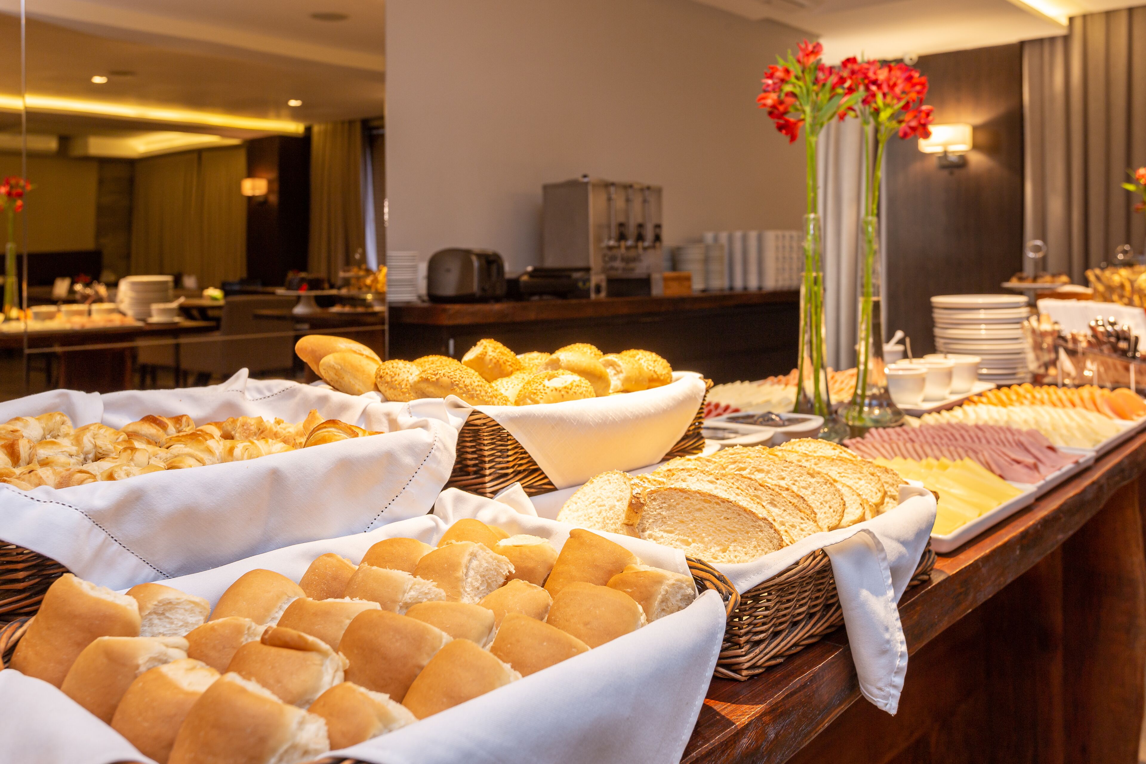 Buffet com diversos pães e doces.