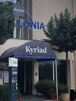 A hotel entrance with a sign reading "Kyriad" and "LONIA".