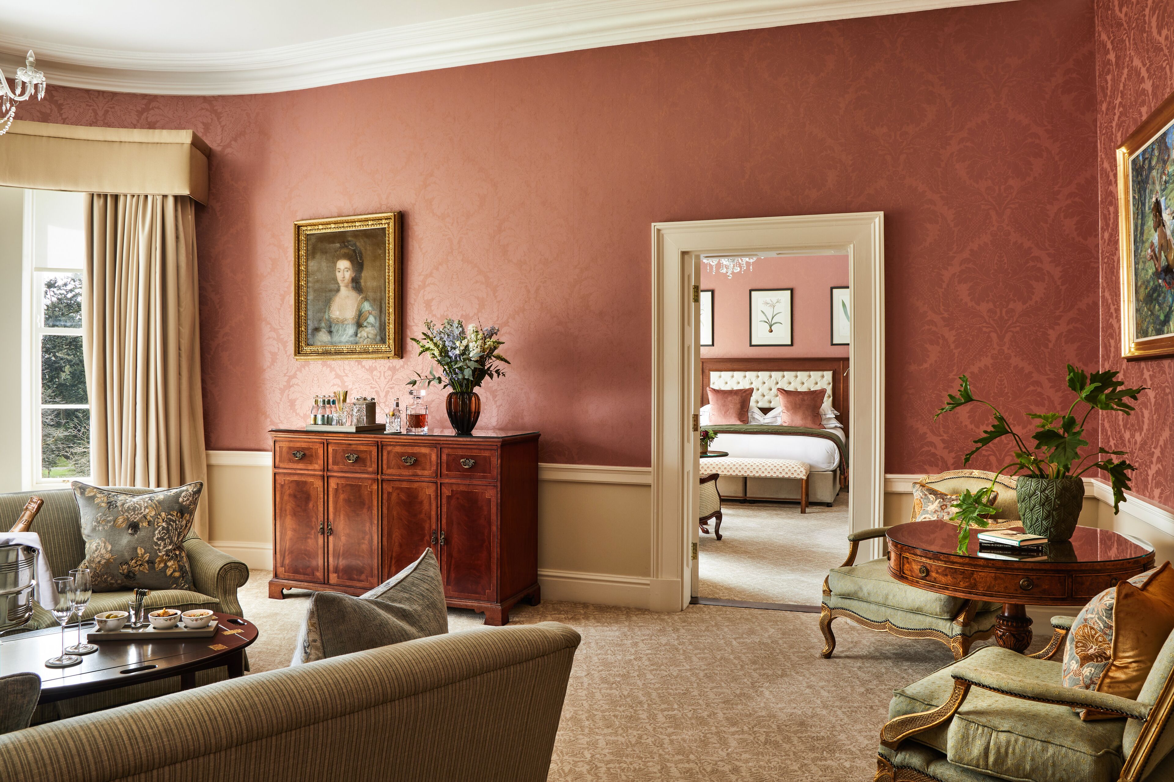 Quarto tradicional com sofá, poltronas, um armário de madeira e uma mesa de jantar.