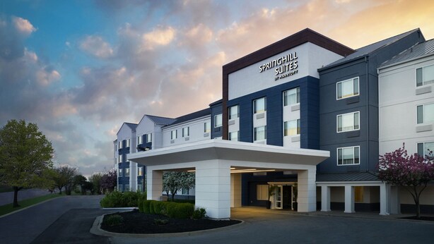 Um hotel moderno com entrada destacada e uma placa com a inscrição