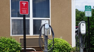 Uma estação de carregamento para veículos elétricos Tesla, com sinalização indicando uso exclusivo para veículos elétricos Tesla.
