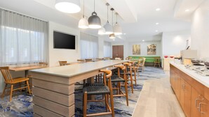 Uma sala de conferências com uma mesa comprida, várias cadeiras e iluminação pendente.