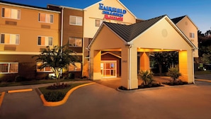 Um hotel Fairfield Inn & Suites Marriott com design moderno, apresentando uma entrada marcante e fachada bem iluminada.