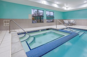 Piscina interior com paredes azulejadas e janelas.