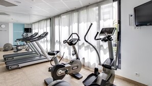 Uma academia moderna com esteiras, elípticos e bicicletas ergométricas.