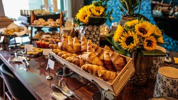 Um buffet com diversos pastéis e uma tábua de servir de madeira.