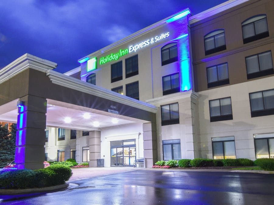 Um Holiday Inn Express & Suites com entrada coberta e céu claro.