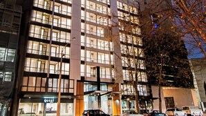 Um edifício de vários andares com design moderno, combinando fachadas de vidro e concreto.