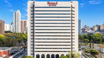 Um edifício de hotel alto e moderno com uma placa de destaque que diz 'Bristol Hotels'.