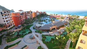 Resort com várias piscinas, palmeiras e vista para a praia.