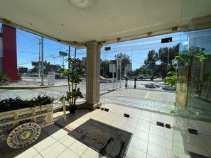 Entrada de hotel com chão de azulejos, tapete de entrada e um tapete decorativo.
