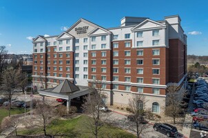 Um hotel com vários andares e uma placa de destaque com a inscrição 'EMBASSY SUITES'.