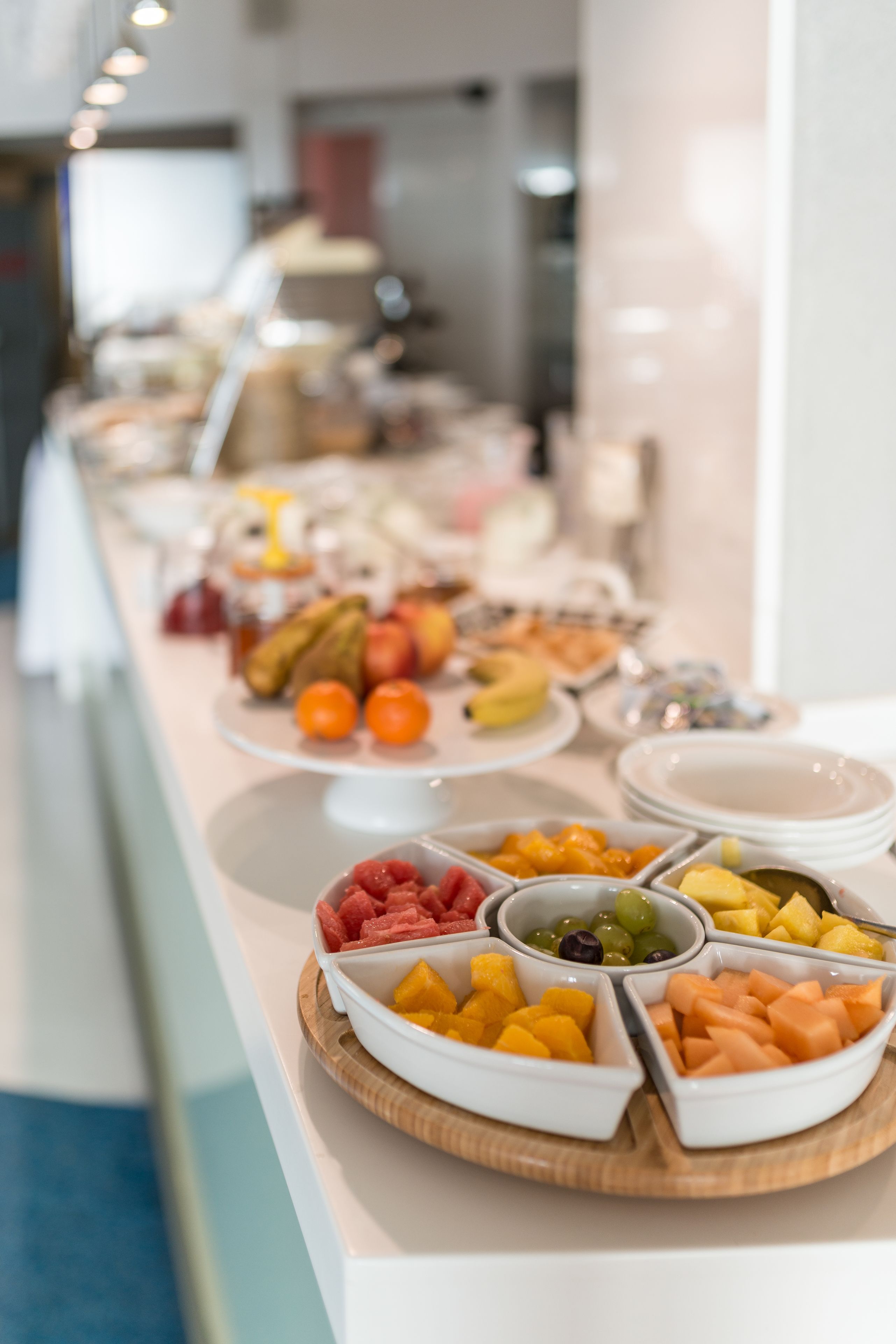 Buffet com diversas frutas e legumes dispostos sobre um balcão.