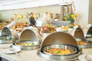 Uma área de buffet com vários pontos de serviço de alimentos, cada um coberto por uma cúpula.