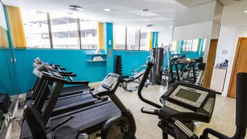 Uma academia com esteiras, elípticos e equipamentos de musculação.
