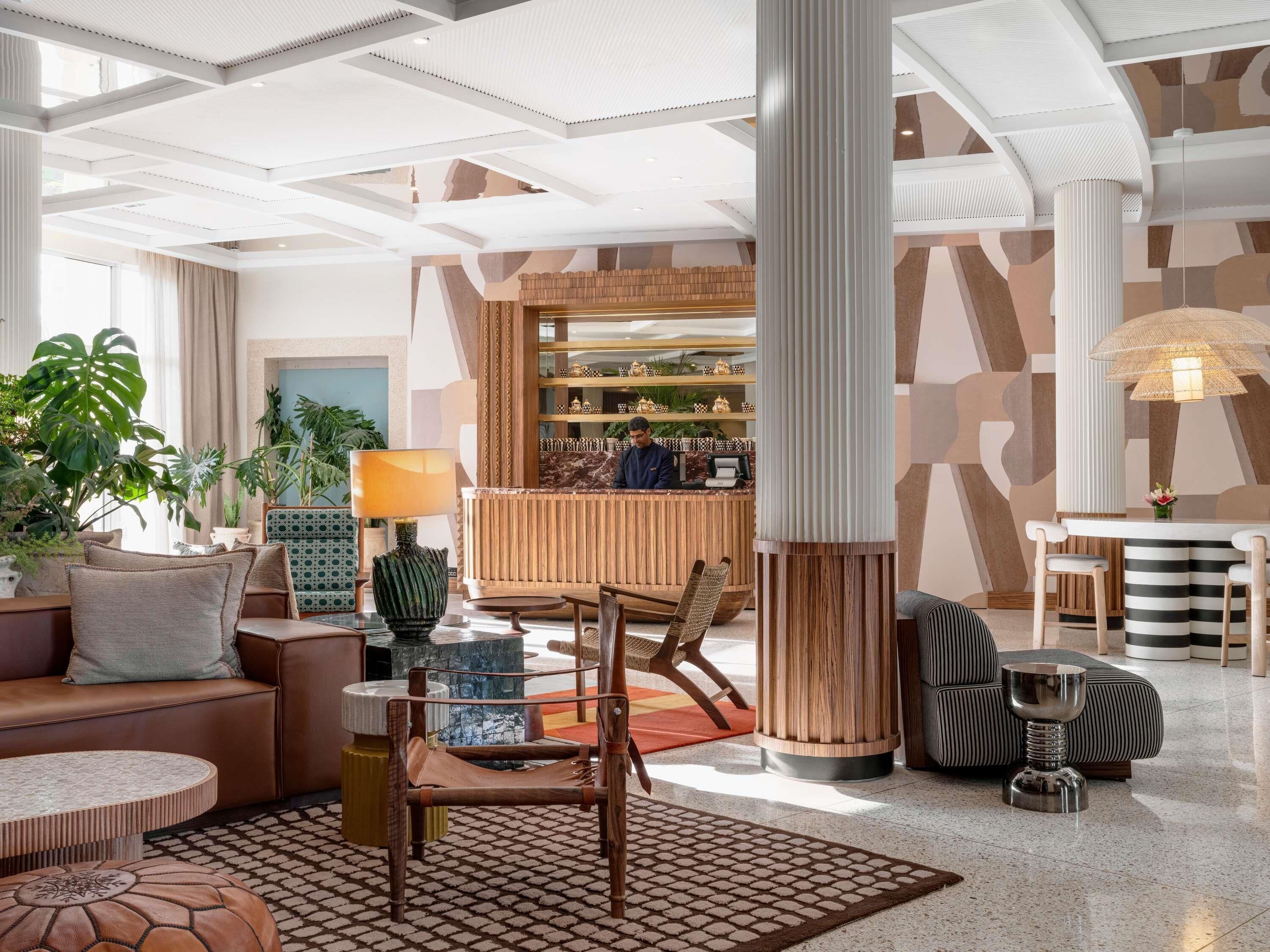 Um hall com balcão de recepção, área de estar e bar.