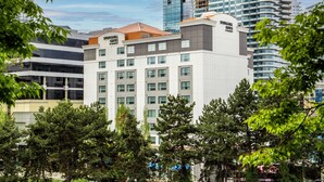 Um hotel moderno com vários andares, grandes janelas e uma placa bem visível da Springhill Suites.