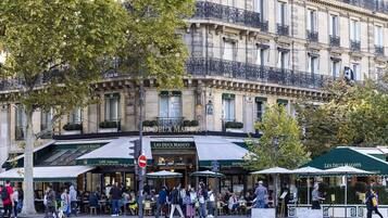 Um edifício histórico com um café chamado "Les Deux Magots" no andar térreo.