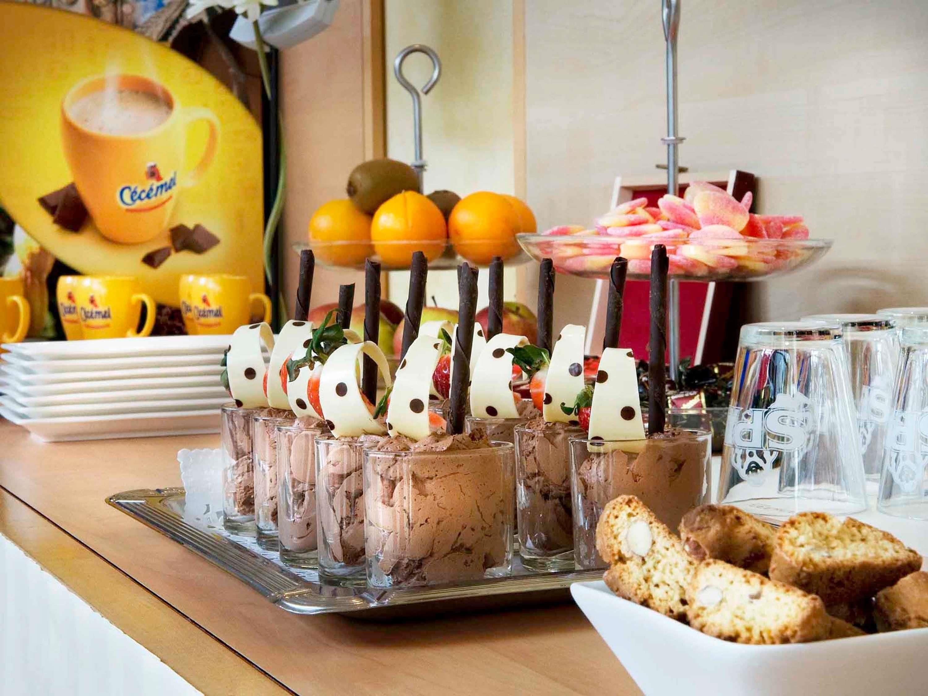 Bandeja de sobremesas com mousse de chocolate, frutas e palitos de chocolate.