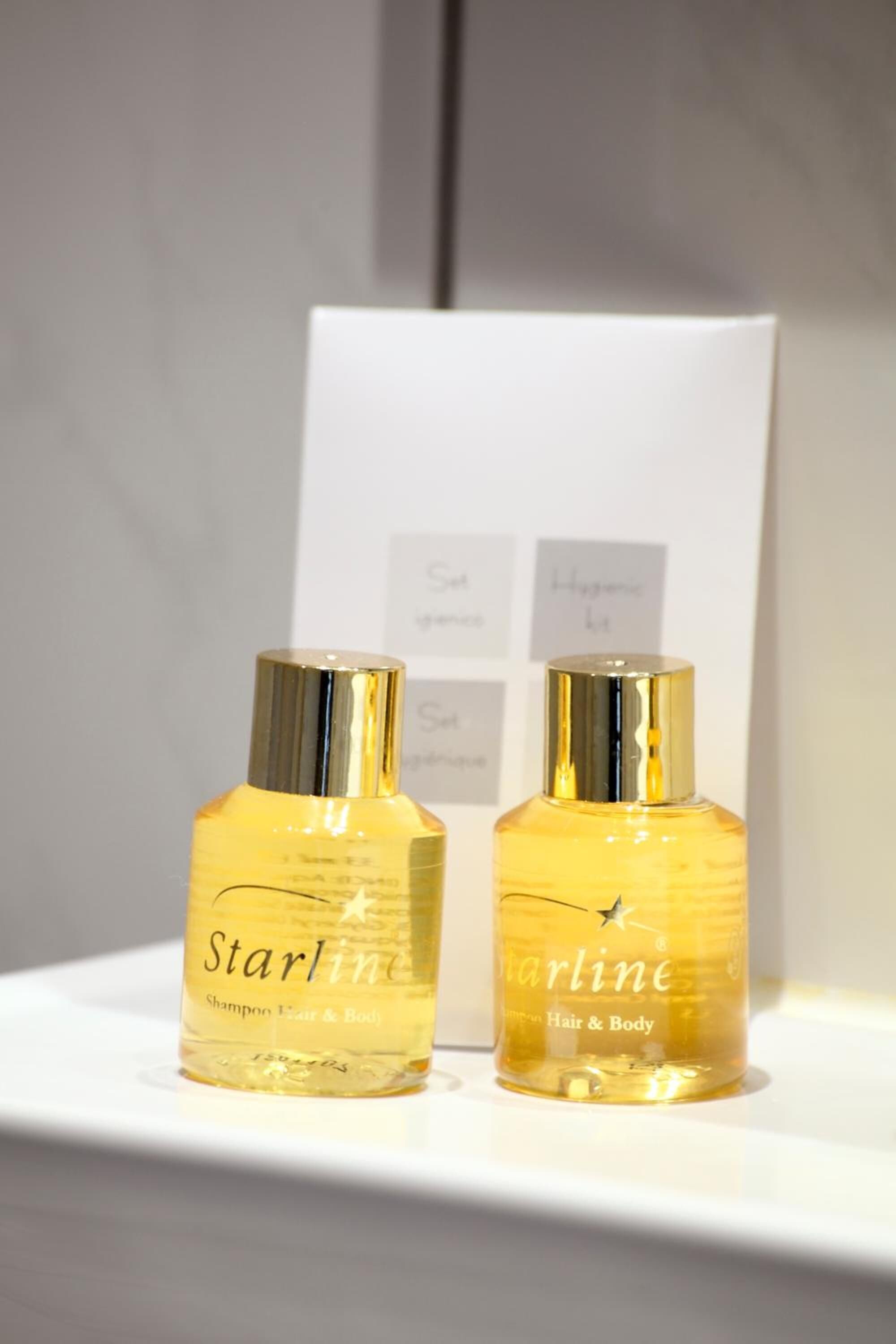 Duas embalagens de shampoo Starline para cabelo e corpo sobre uma superfície branca.