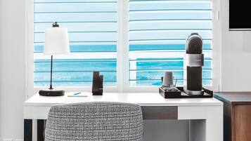 Um espaço de trabalho moderno com escrivaninha, cadeira e máquina de café, com vista para a costa.