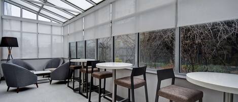 Um interior moderno com teto de vidro, disposição de assentos e amplas janelas.