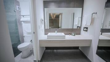 Uma casa de banho moderna com um espelho grande, uma sanita branca e uma casa de banho.