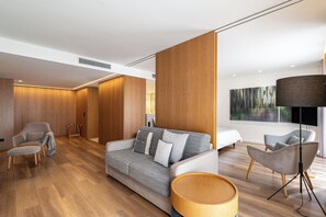 Suíte com design assinado, sacada | Área de estar | TV de tela plana, filmes pagos
