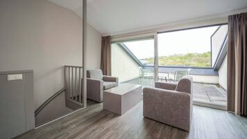 Sala de estar moderna com uma grande janela, escada e vista para o verde lá fora.