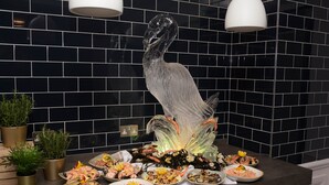 Uma bancada de cozinha com diversos pratos de frutos do mar e uma escultura de vidro decorativa.
