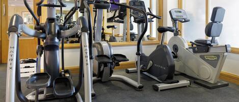 Uma academia com diversos equipamentos de cardio, incluindo esteiras e elípticos.