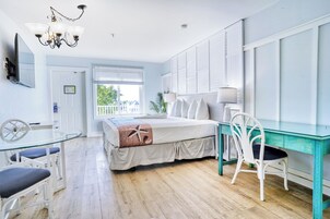 Um quarto com uma cama, uma escrivaninha e uma cadeira.
