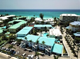 Um resort com vários edifícios, estacionamento e vista para o oceano.