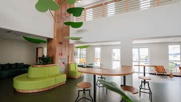 Um interior moderno com um sofá verde curvo, uma parede de destaque em madeira e uma mesa redonda central com bancos.