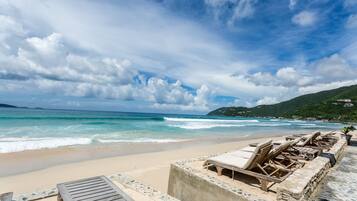 Uma praia com cadeiras de praia e vista para o oceano.