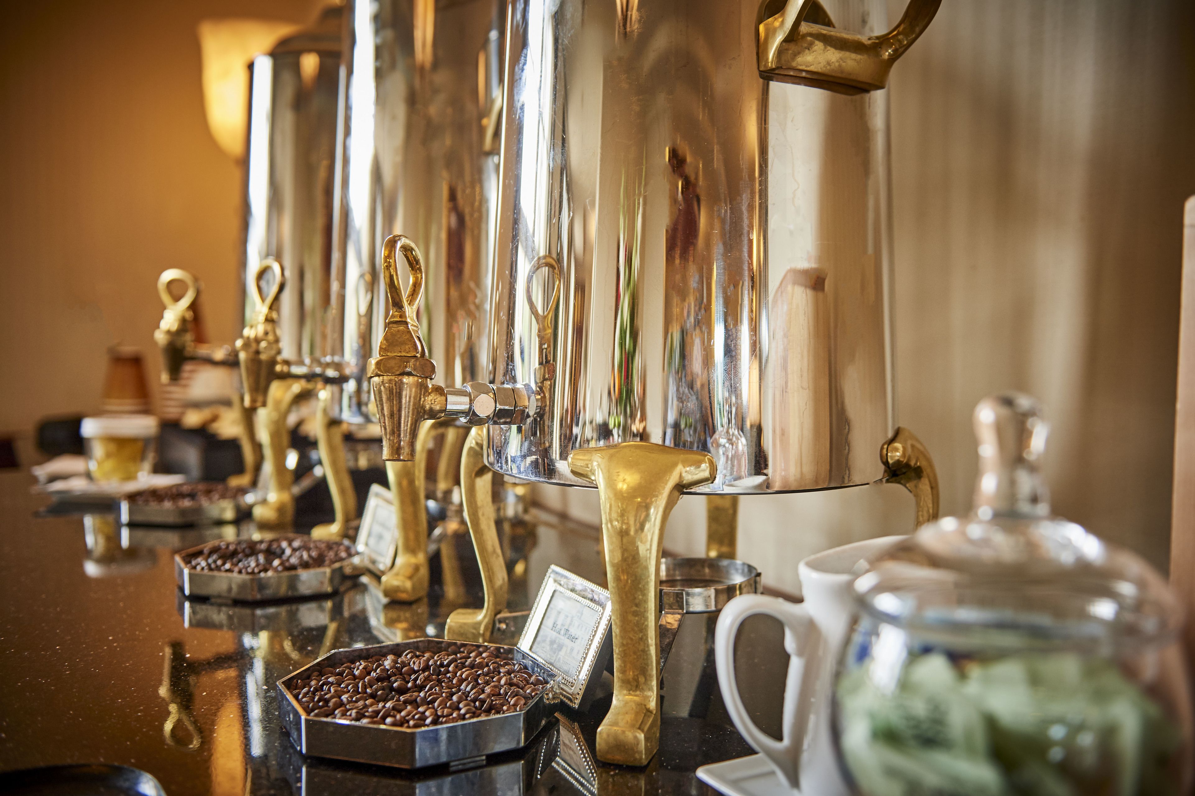 Uma estação de café com vários dispensadores e uma cafeteira.