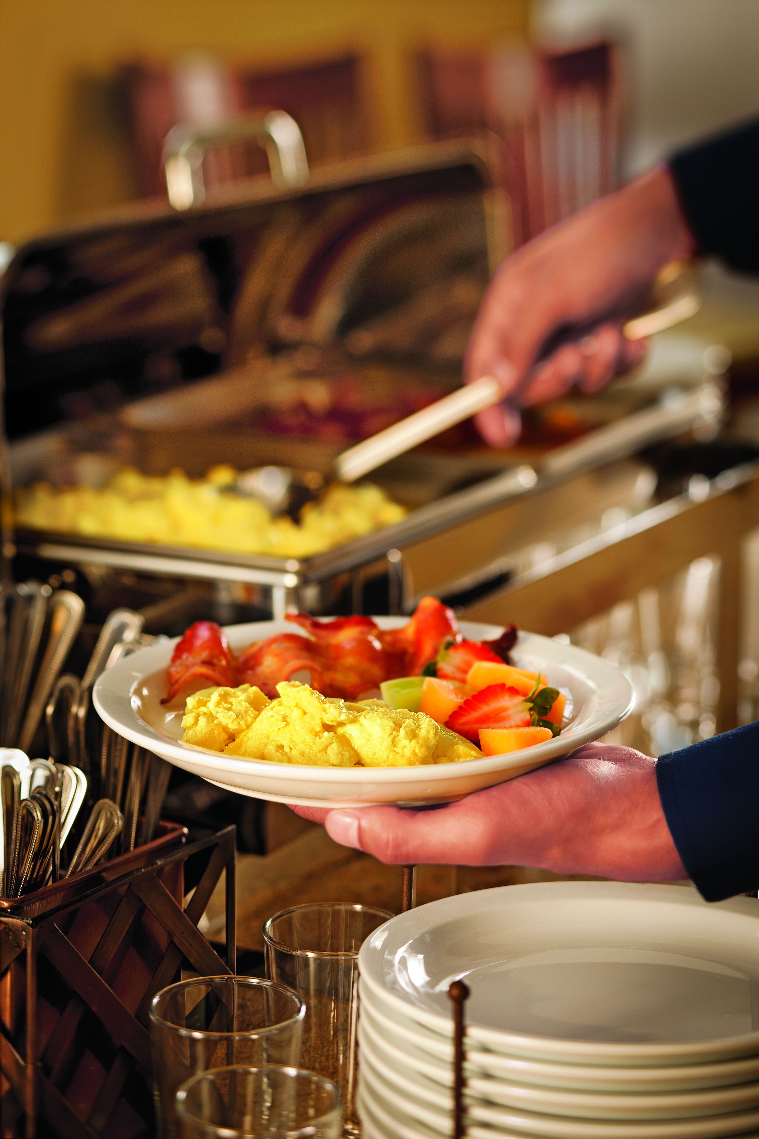 Disposição de buffet com um prato de comida sendo servido.