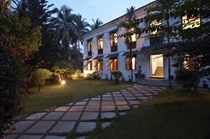 Um edifício de dois andares com um caminho de jardim que leva à entrada.