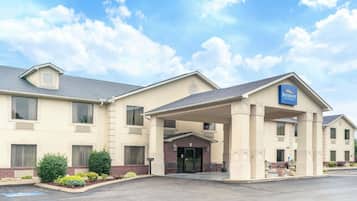Um Baymont Inn & Suites com entrada coberta, fachada de tijolos e estacionamento.